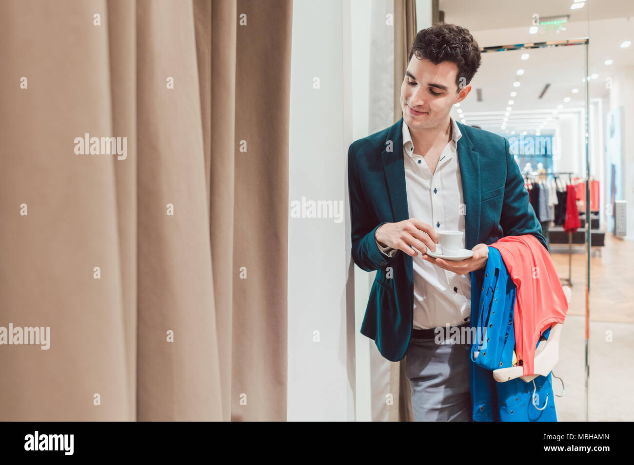 Man in fashion store waiting for his woman to appear from the fitting ...