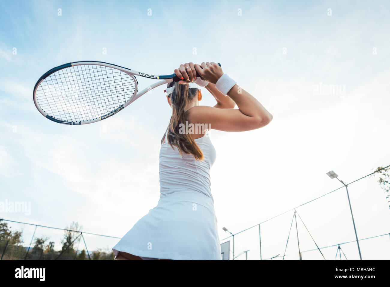 Woman giving return playing tennis Stock Photo - Alamy