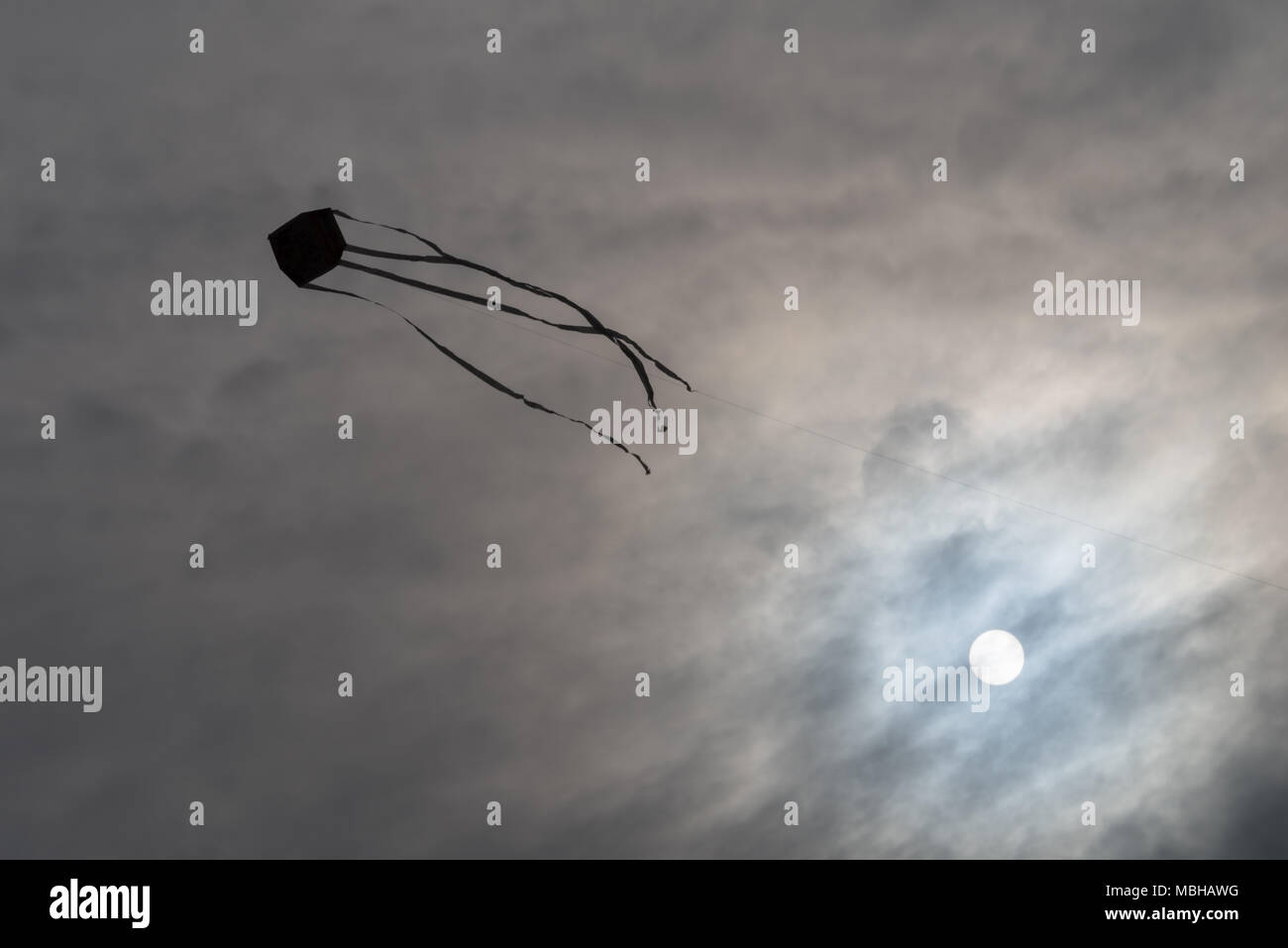 A kite fly against sun and dramatic storm clouds Stock Photo - Alamy