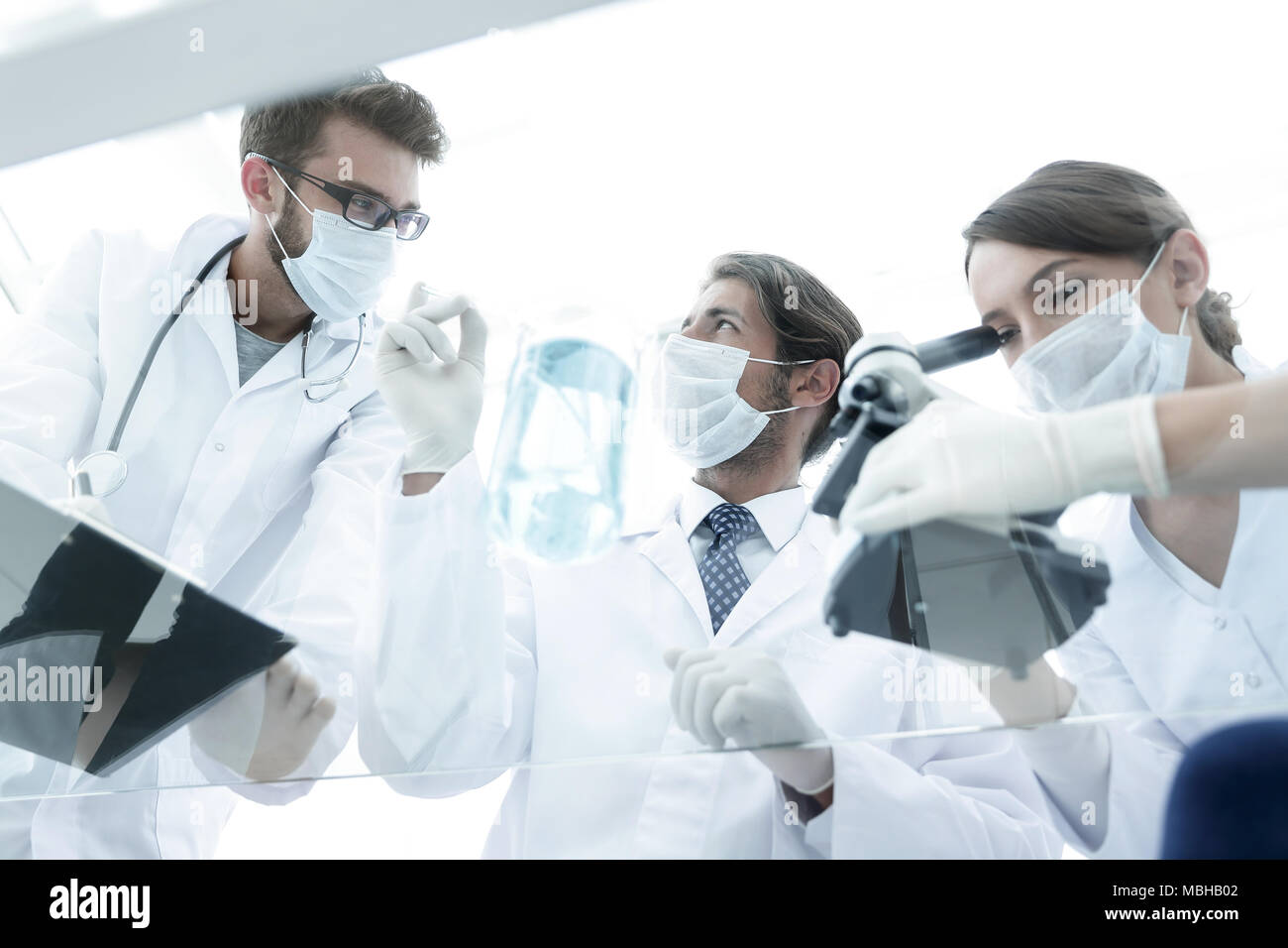 three young scientists who conduct experiments while sitting in the ...