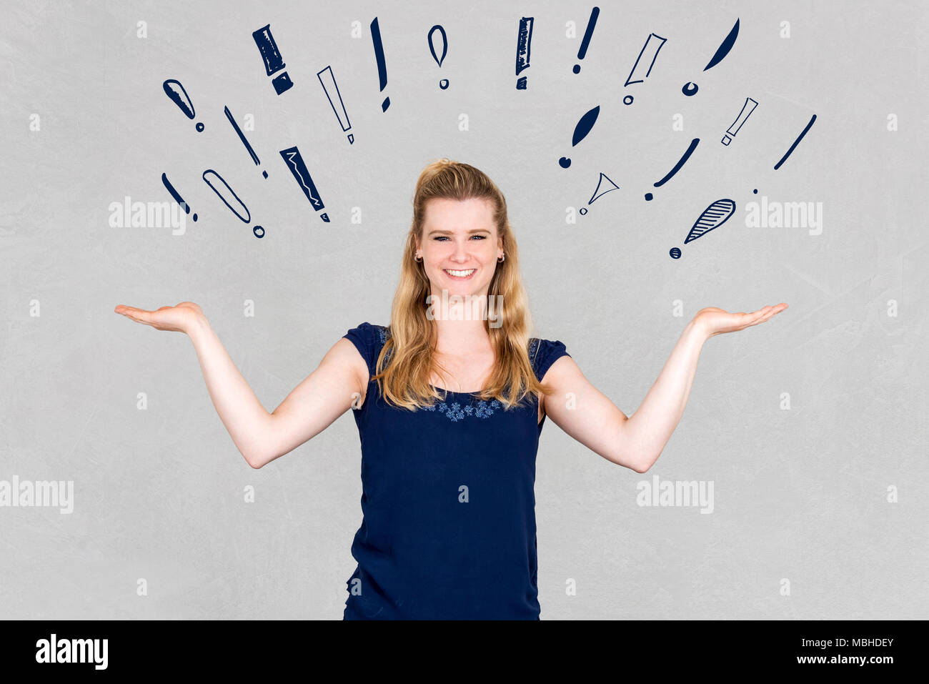 Happy attractive woman holding hands up with exclamation marks around ...