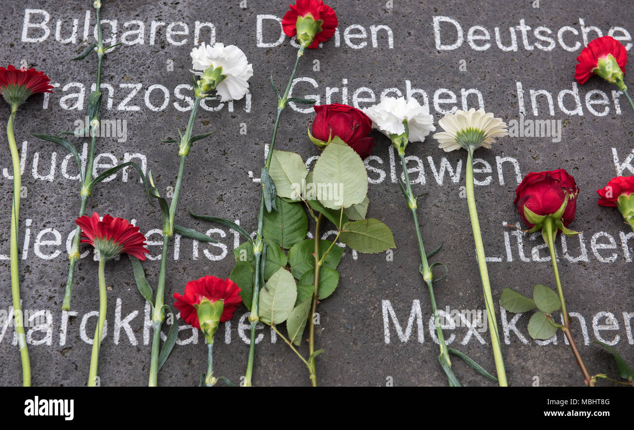 11 April 2018, Germany, Nordhausen: Participants place flowers on a ...