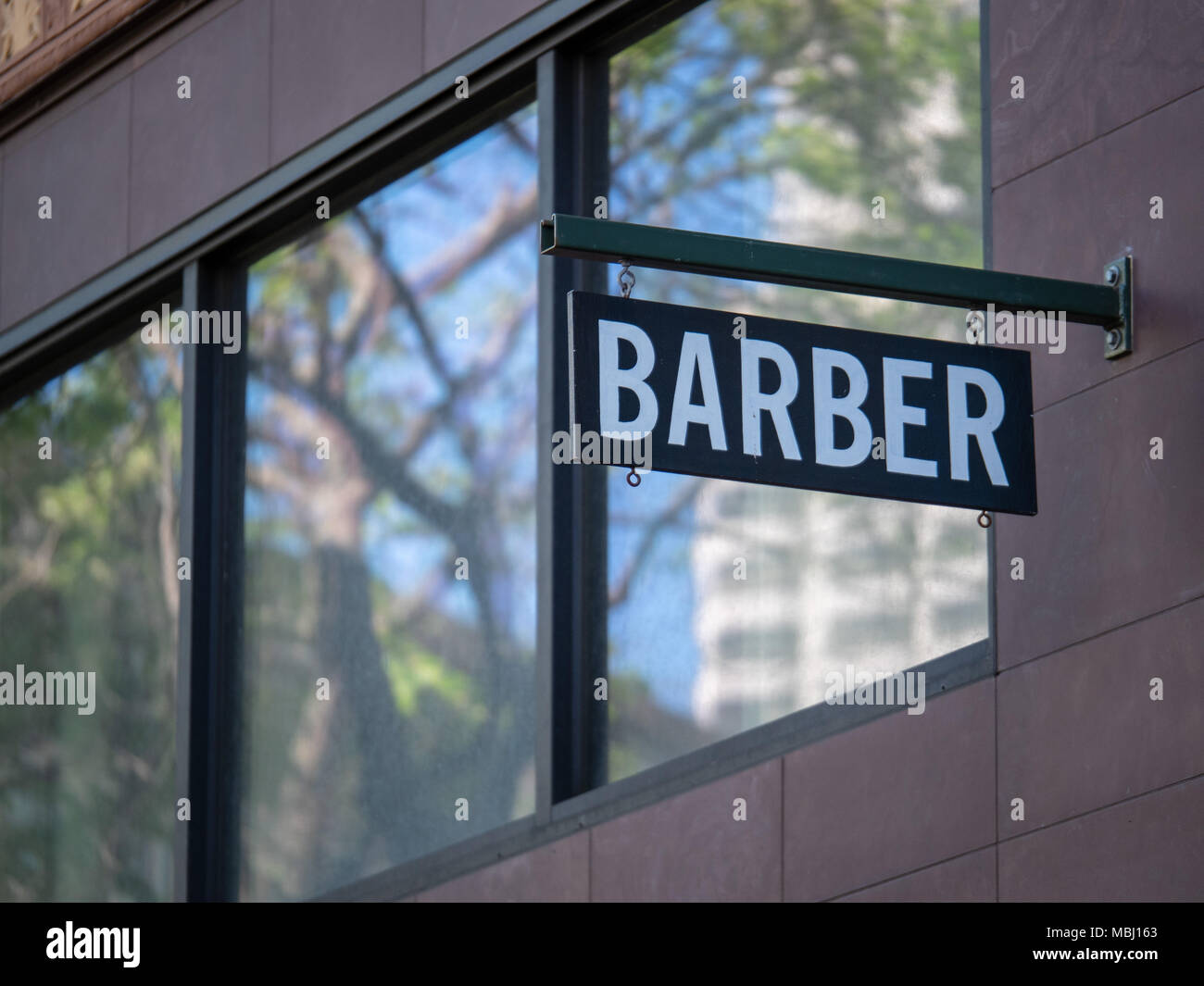 Modern Barber sign hanging outside the shop in an urban environment ...