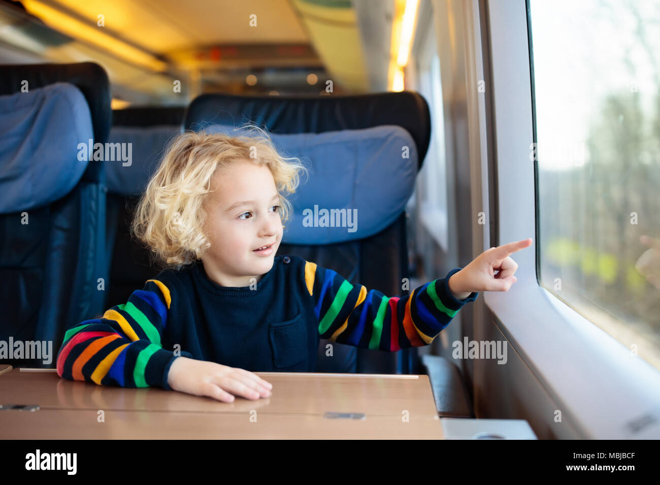 Child traveling by train. Little kid in a high speed express train on ...