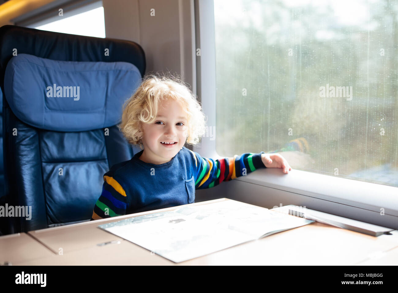 Child traveling by train. Little kid in a high speed express train on ...