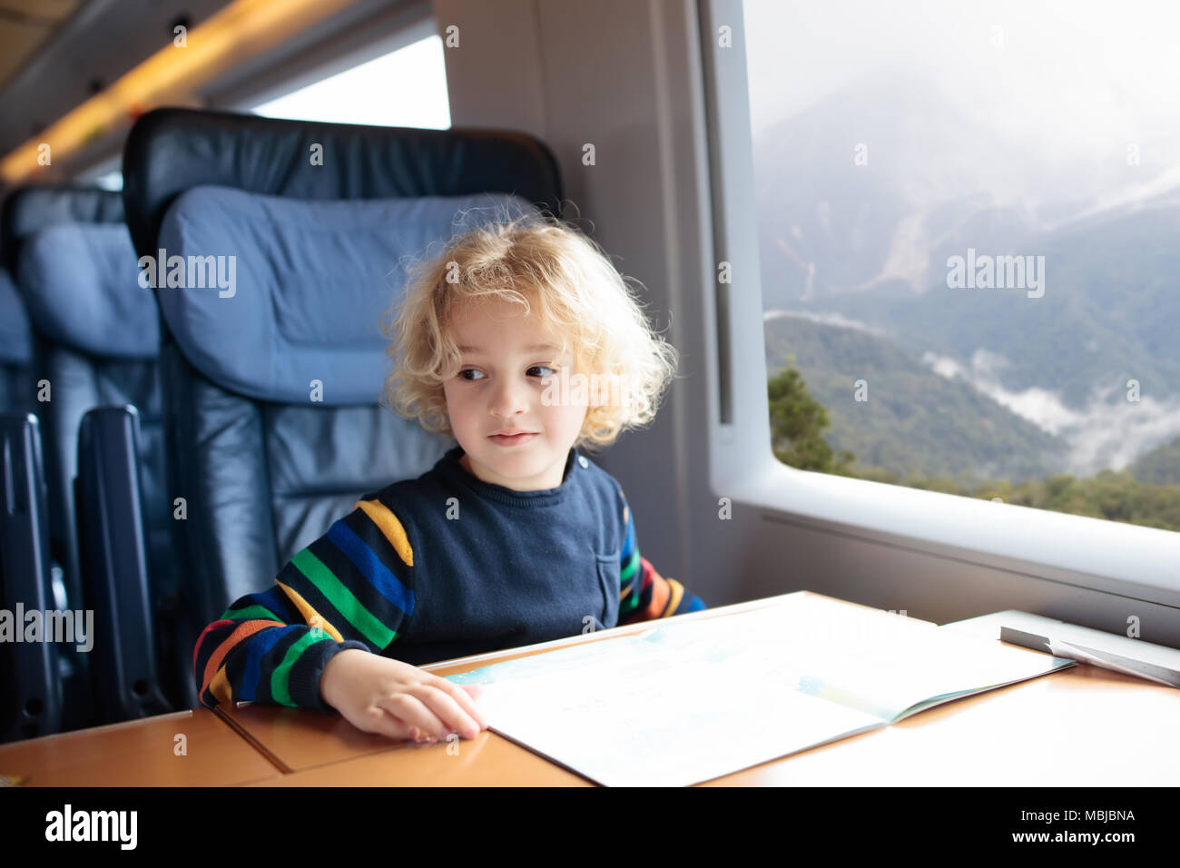 Child traveling by train. Little kid in a high speed express train on ...