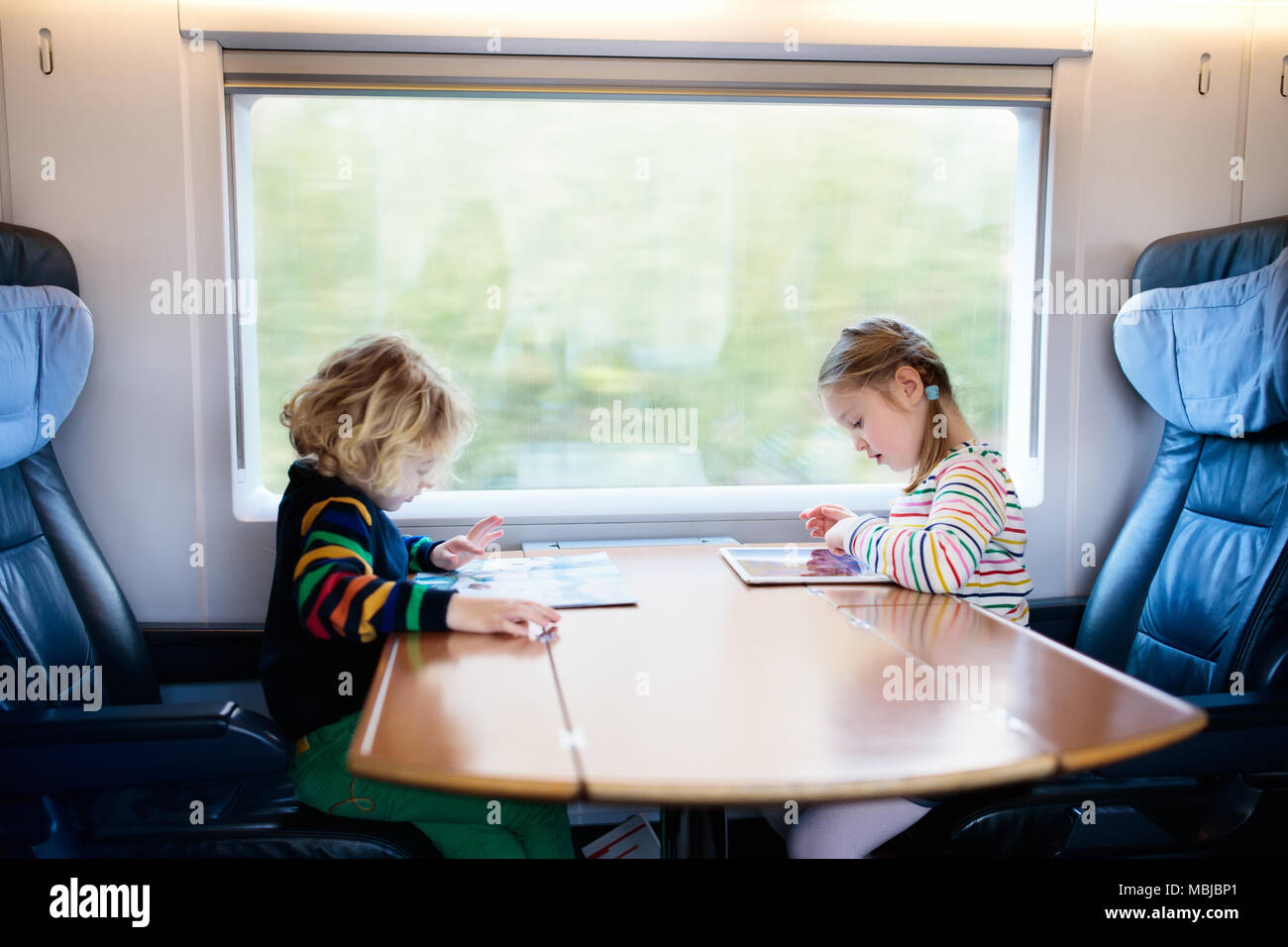 Child traveling by train. Little kid in a high speed express train on ...