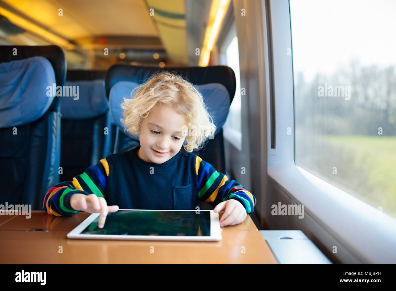 Child traveling by train. Little kid in a high speed express train on ...