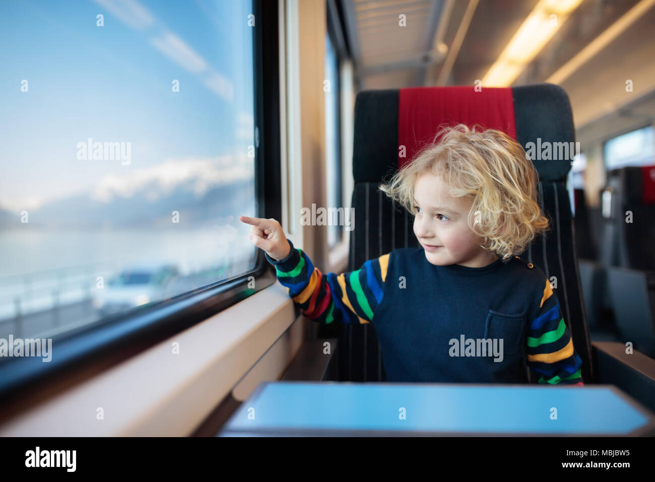 Child traveling by train. Little kid in a high speed express train on ...