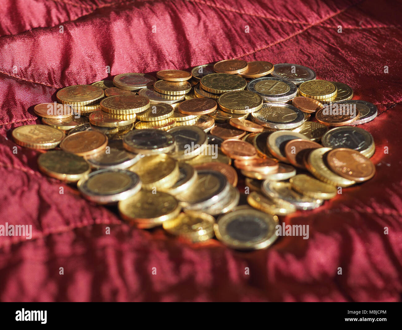 Euro coins money (EUR), currency of European Union over crimson red ...