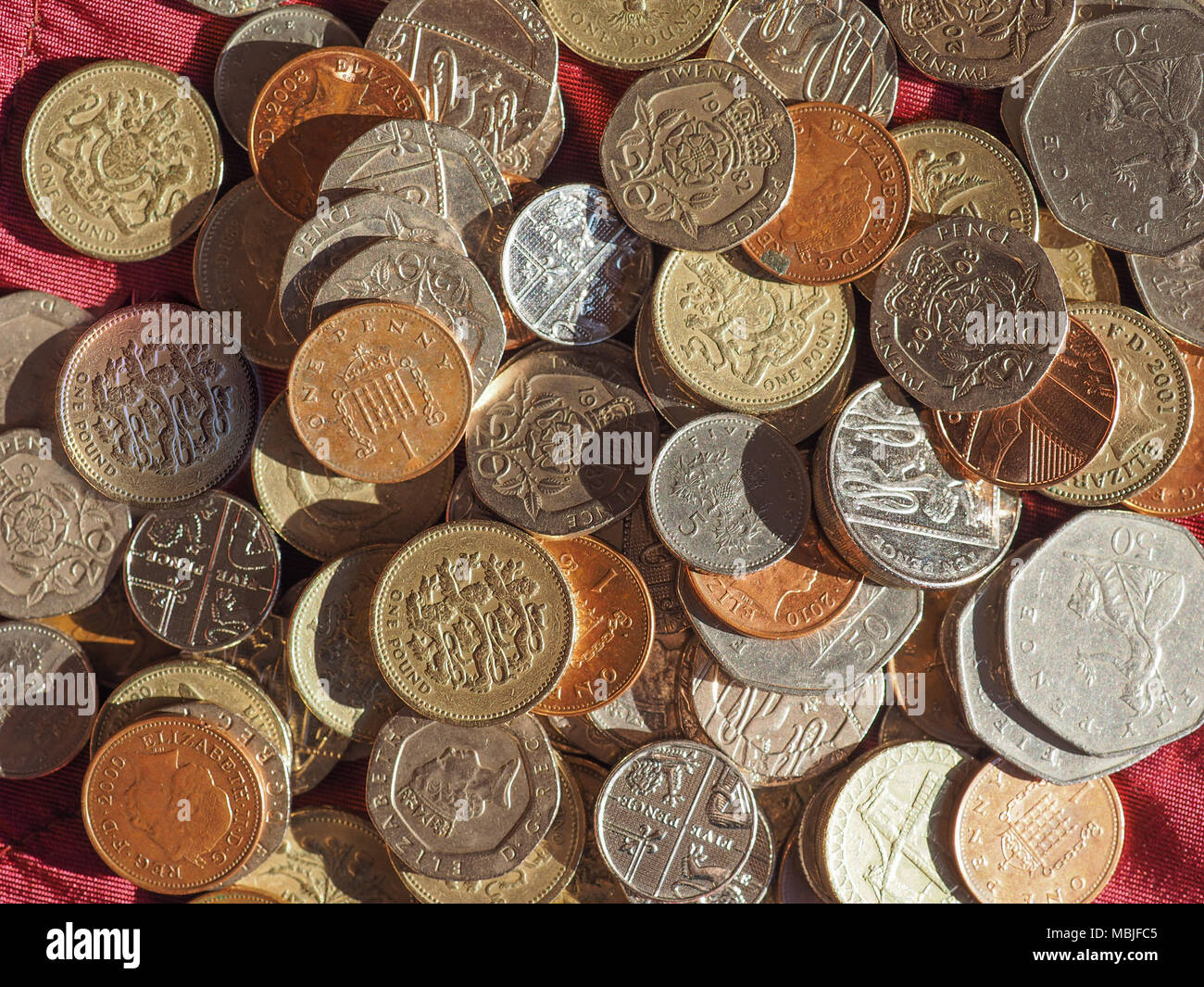 Pound coins money (GBP), currency of United Kingdom over crimson red ...
