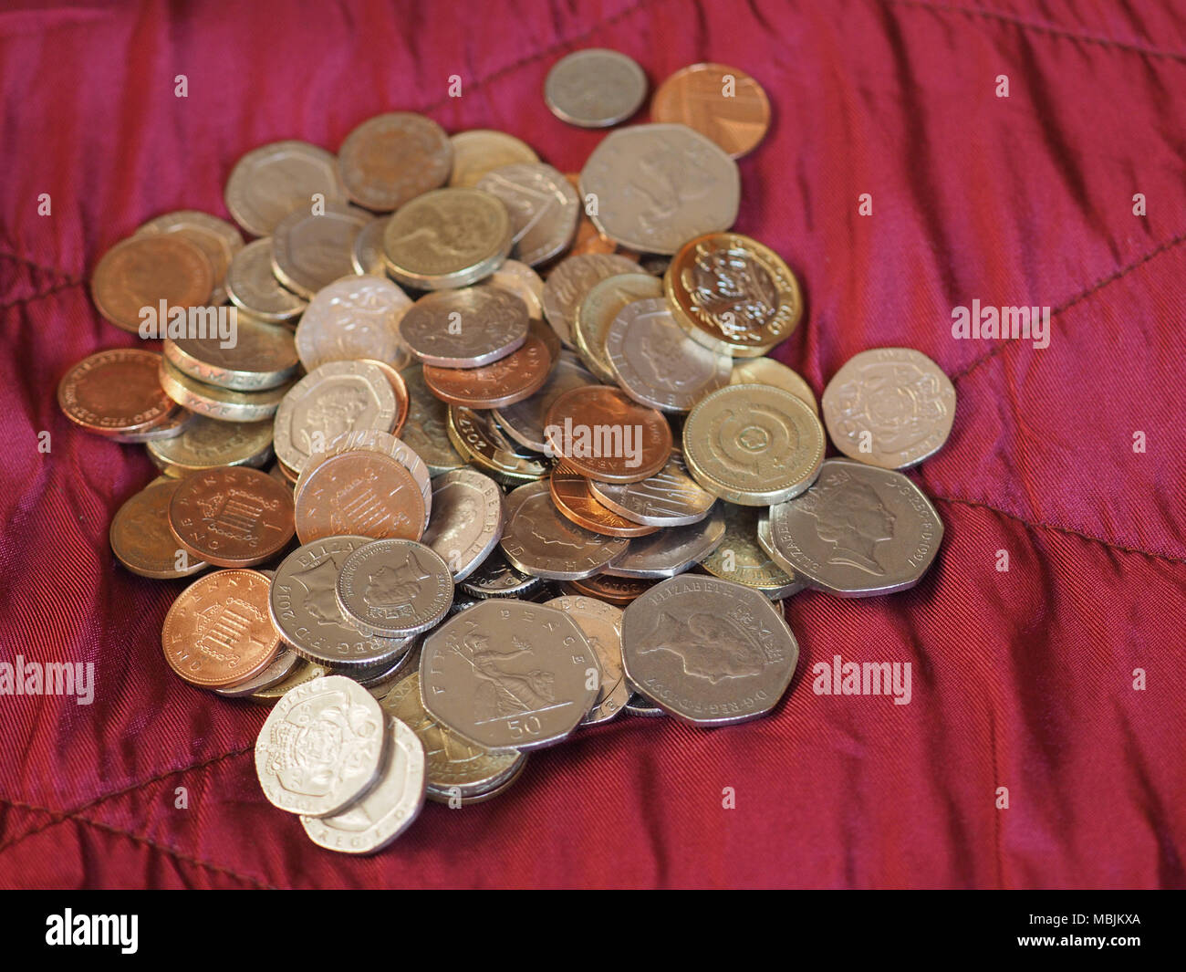 Pound coins money (GBP), currency of United Kingdom over crimson red ...