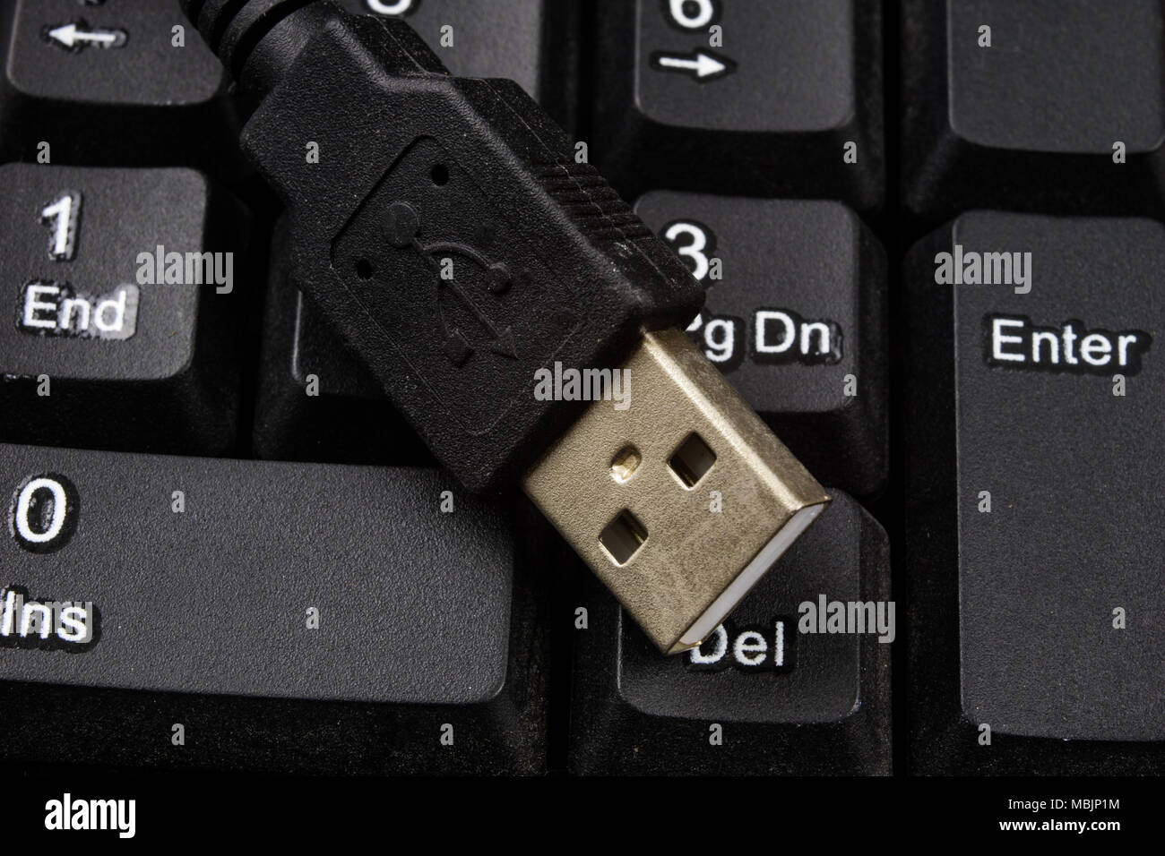 A black computer keyboard and an enlarged USB port. Computer ...
