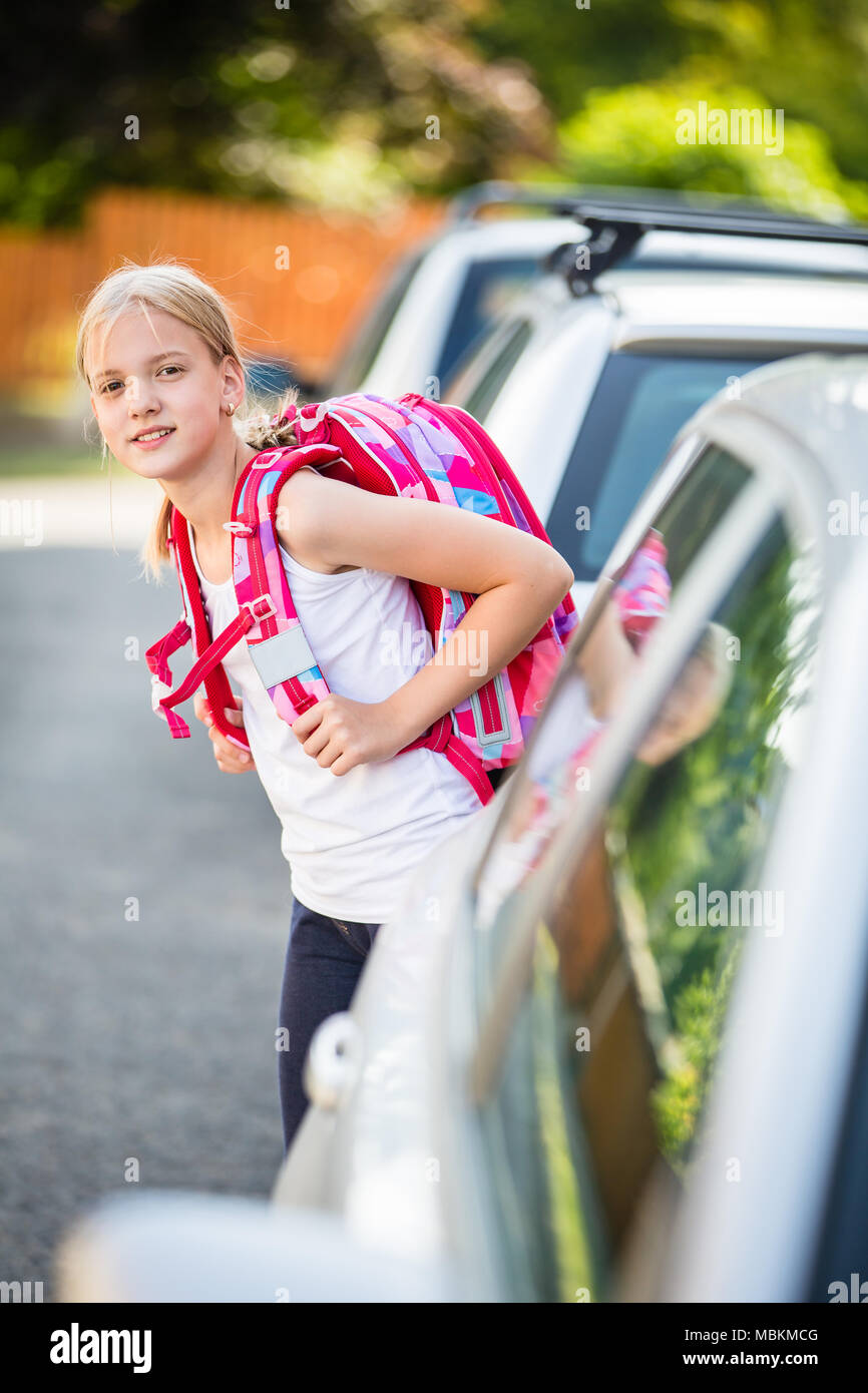Cute little girl going home from school, looking well before crossing ...