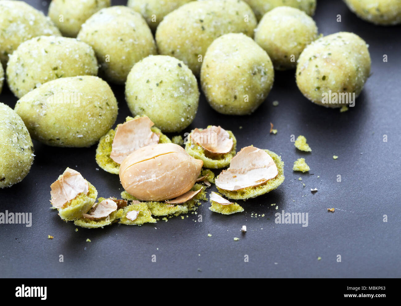 Wasabi seaweed coated peanuts on black plate Stock Photo - Alamy