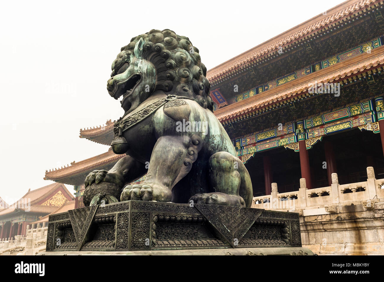 A bronze lion statue in front of Taihe Gate of Forbidden City enveloped ...
