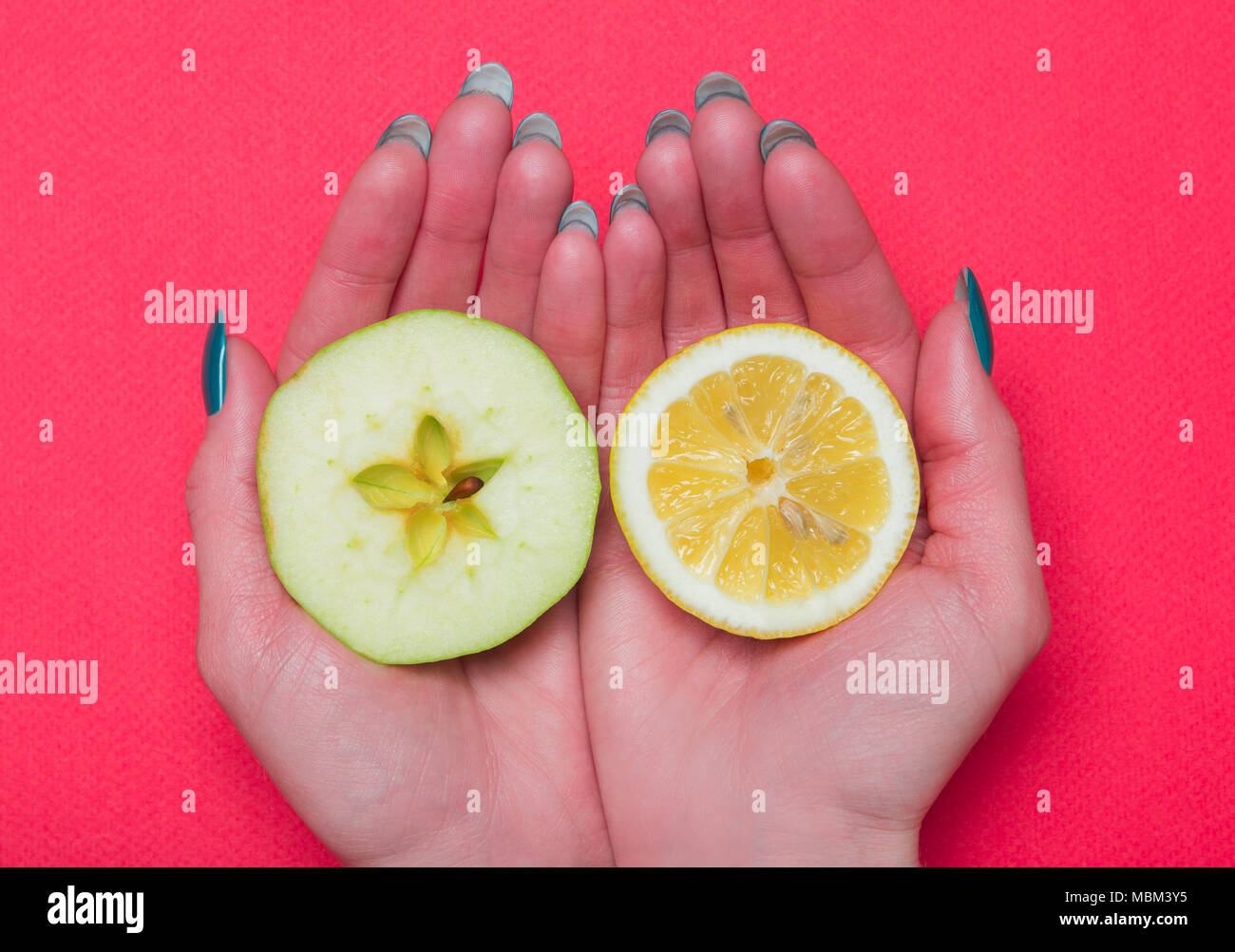 Halves of different fruit lying on the hands Stock Photo - Alamy