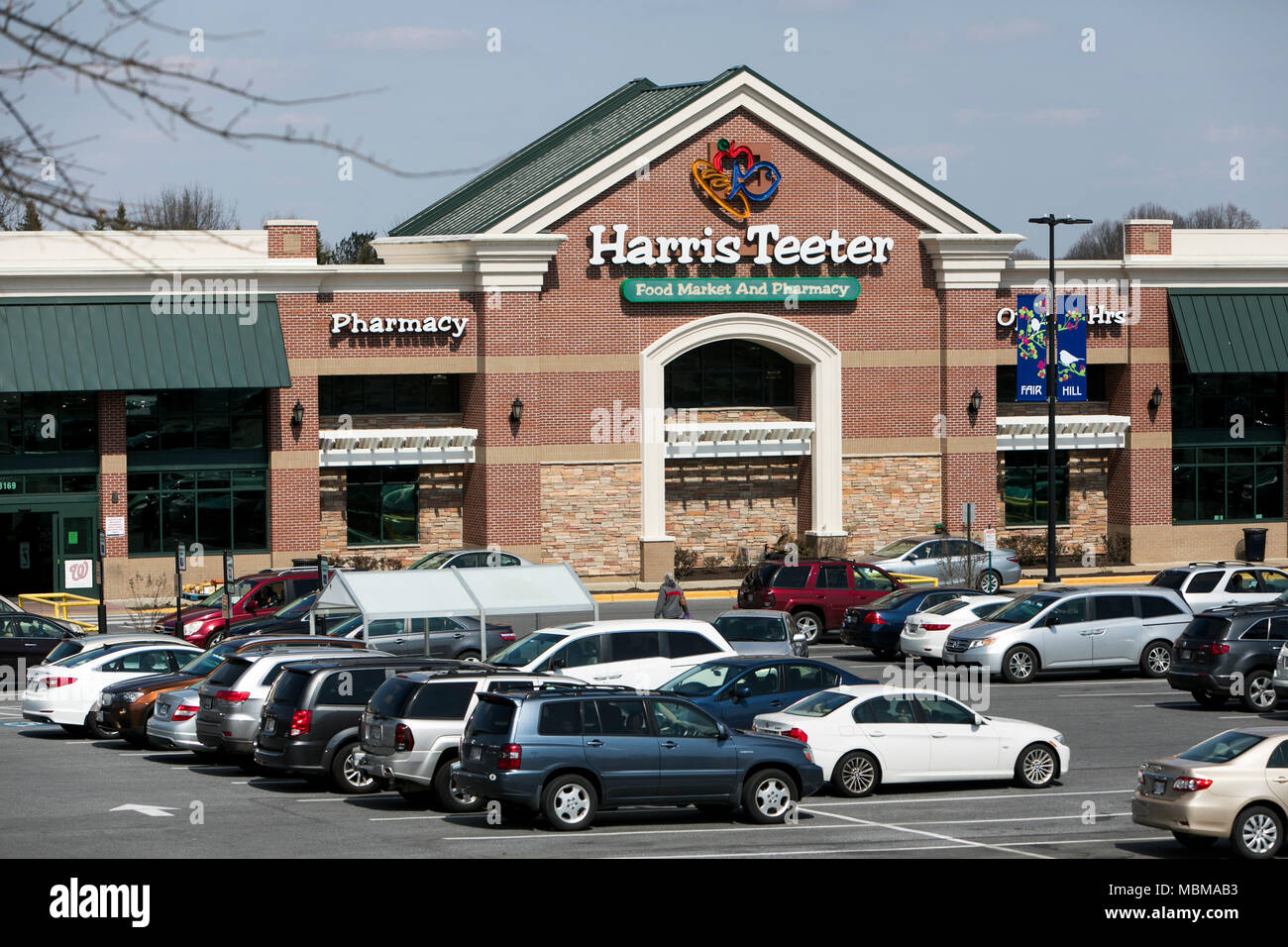 A logo sign outside of a Harris Teeter grocery retail store location in ...