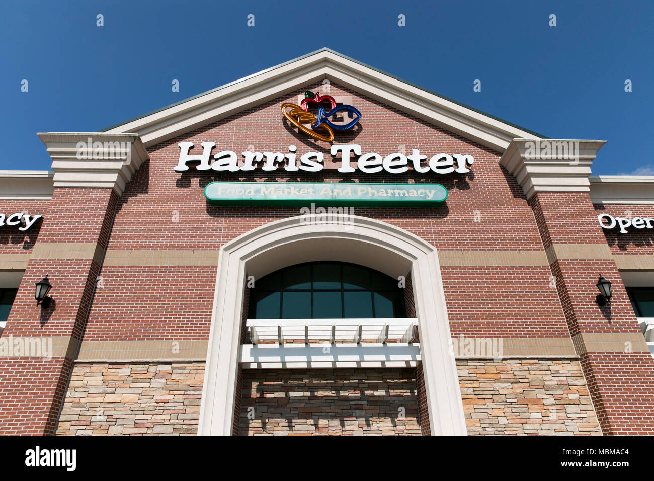 A logo sign outside of a Harris Teeter grocery retail store location in ...