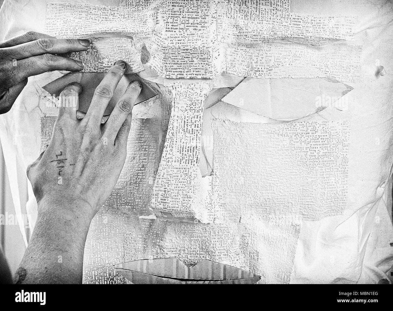 Textured image in black and white of artists hands working with plaster ...