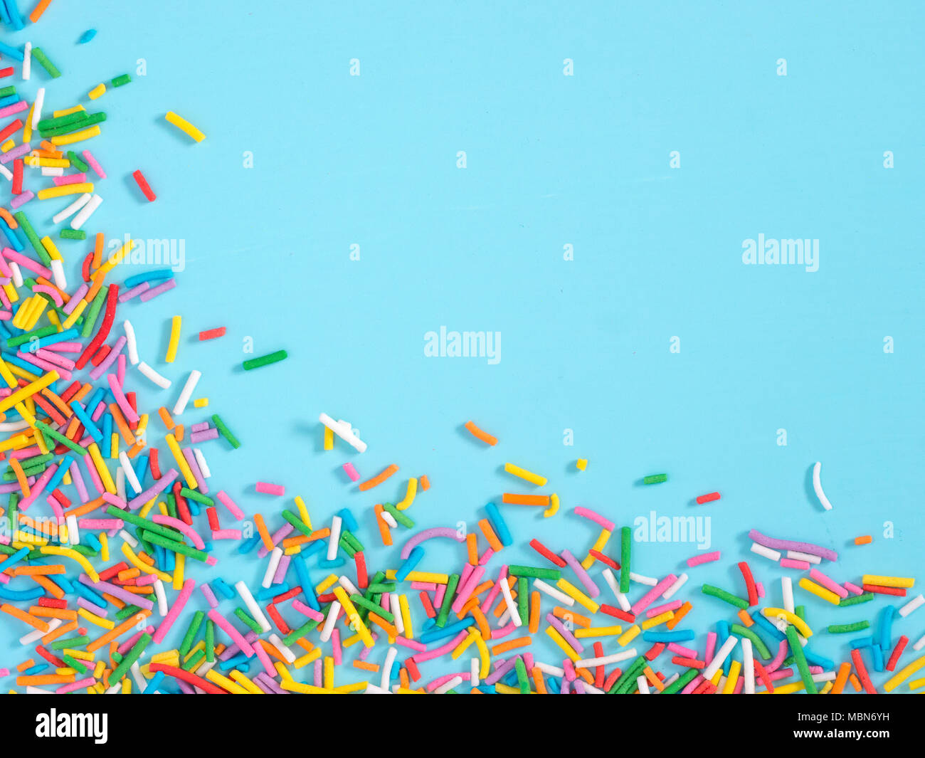 Border frame of colorful sprinkles on blue background with copyspace ...