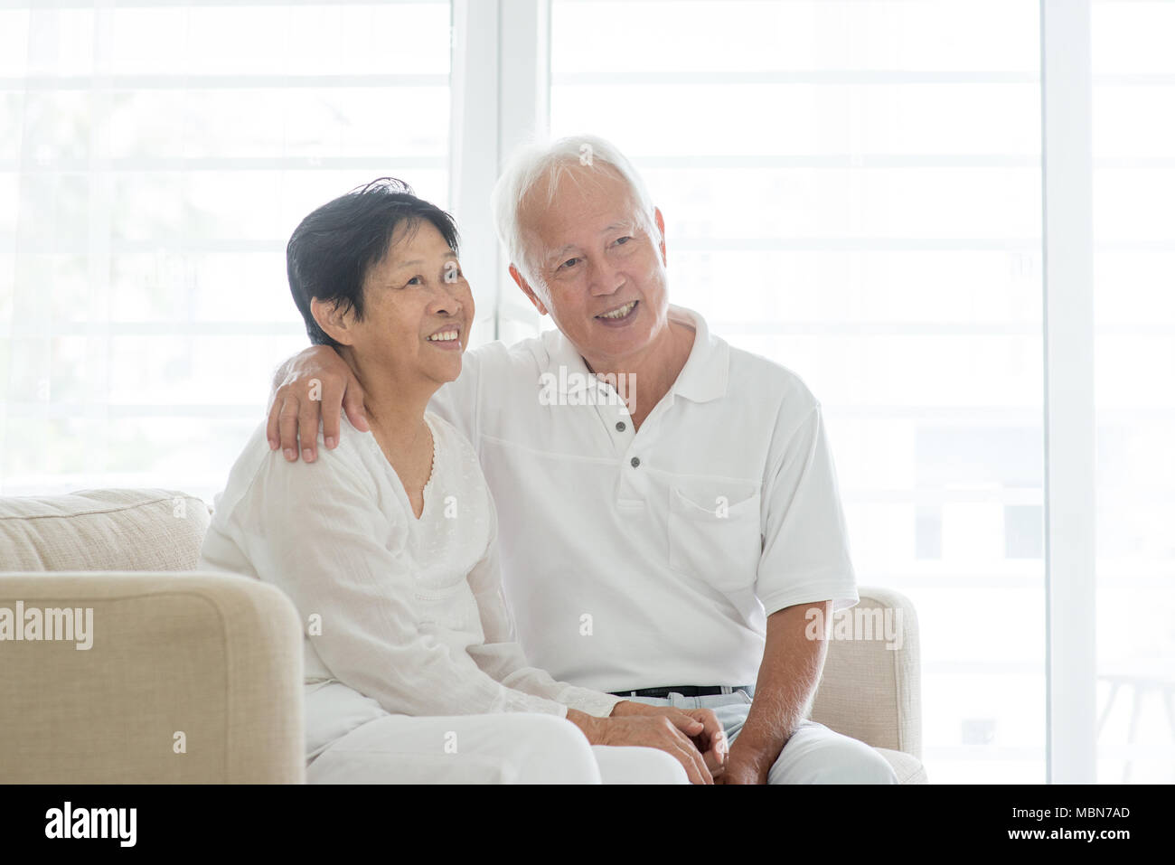 Portrait of happy Asian elderly couple at home, looking away, old ...