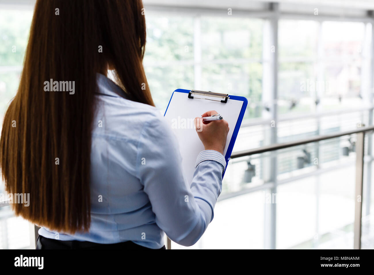 Business woman standing and writing on paperboard Stock Photo - Alamy
