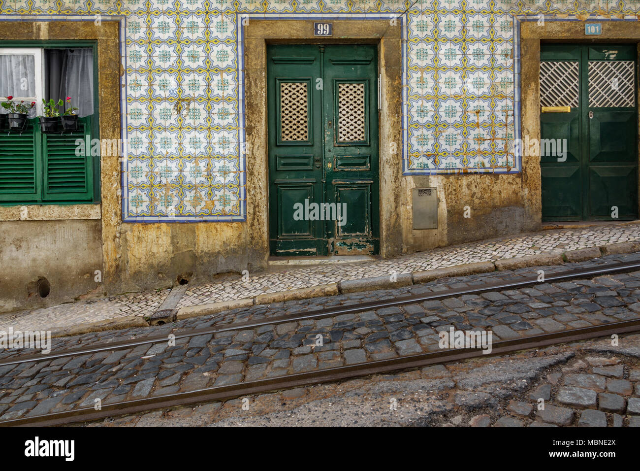 Lisbon high slope street with rail and tile facade Stock Photo - Alamy