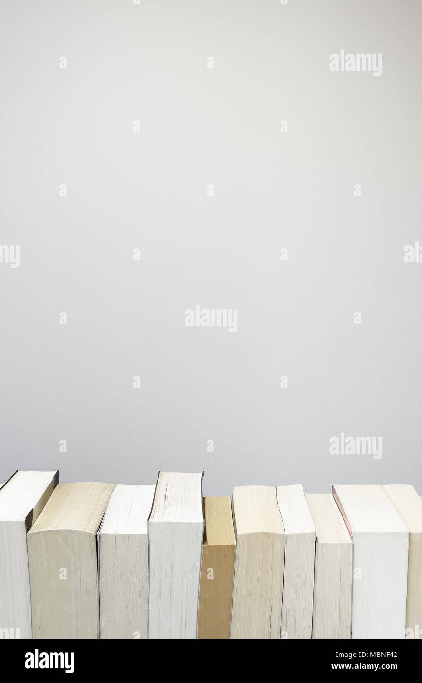 Books in a row on light grey background Stock Photo - Alamy