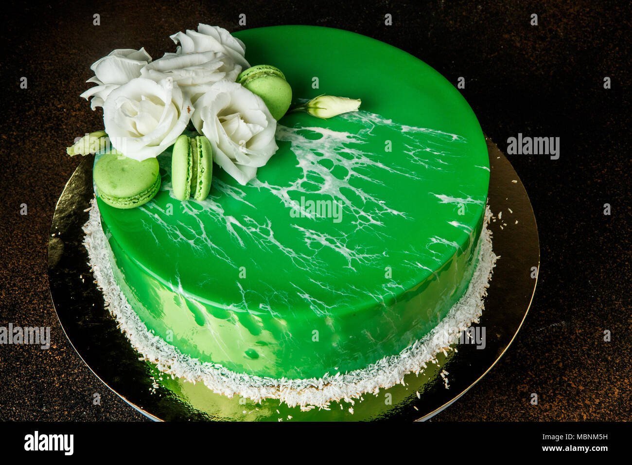 glazed mousse green cake decorated with white roses and mint macaroons ...