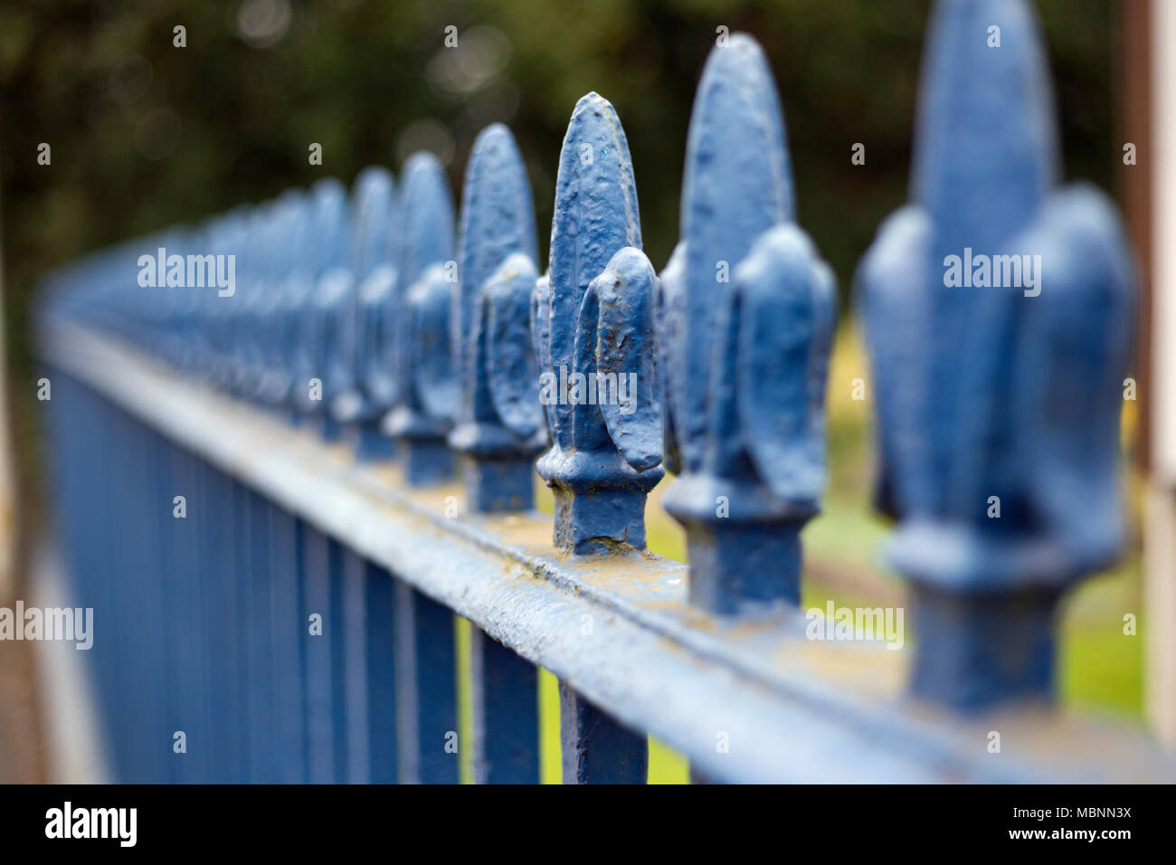 Receding blue wrought iron railings with a fleur de lis top Stock Photo ...