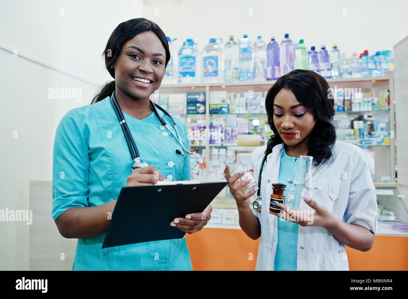 Two african american pharmacist working in drugstore at hospital ...