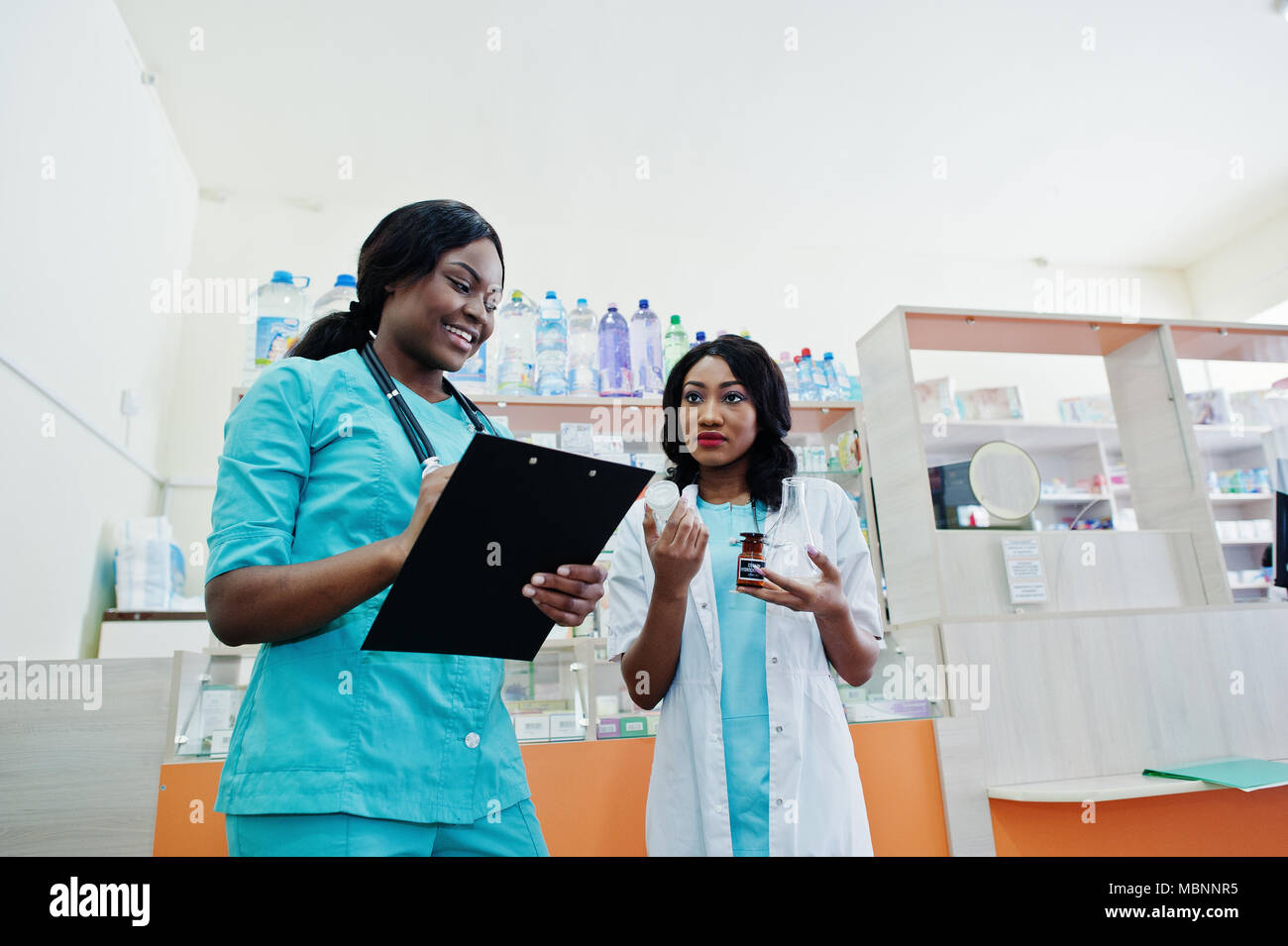 Two african american pharmacist working in drugstore at hospital ...