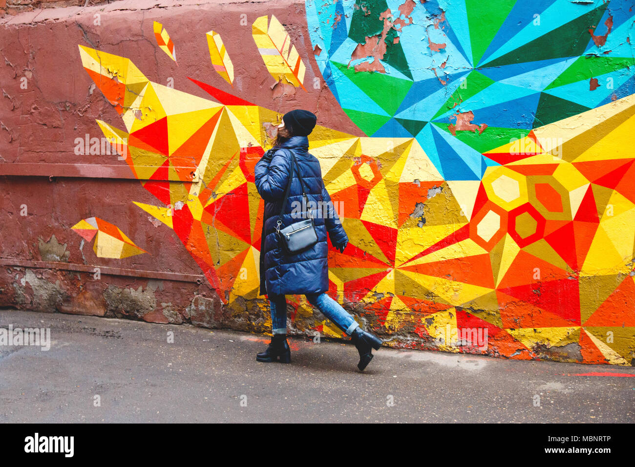 girl walking along the colorful wall, street photo Stock Photo - Alamy