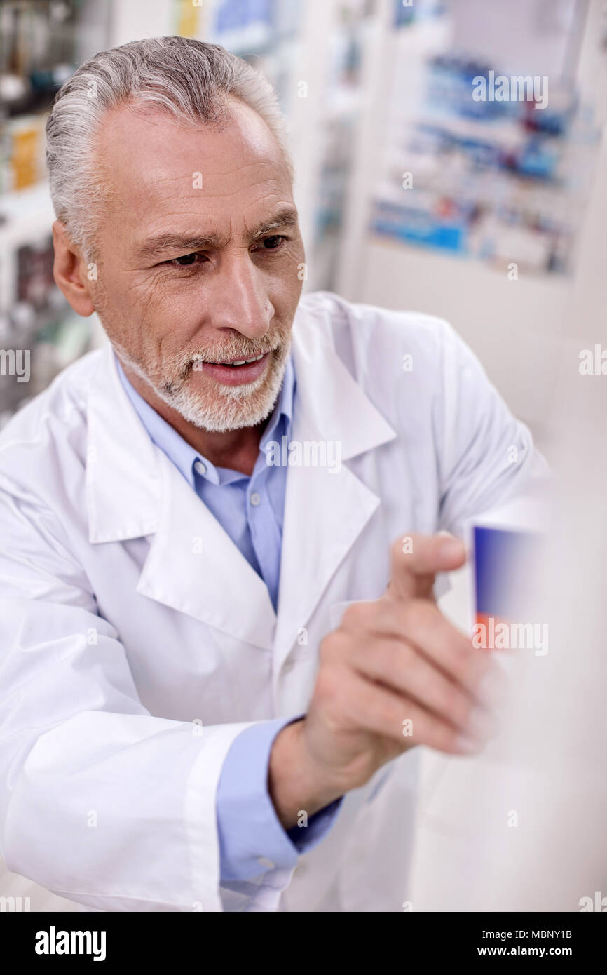 Handsome male pharmacist placing drug Stock Photo - Alamy