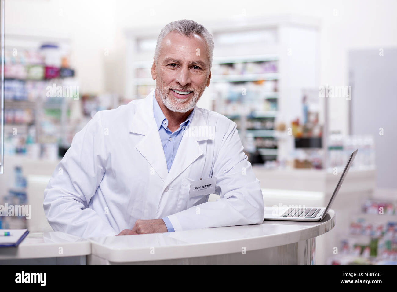 Positive male pharmacist working in drugstore Stock Photo - Alamy