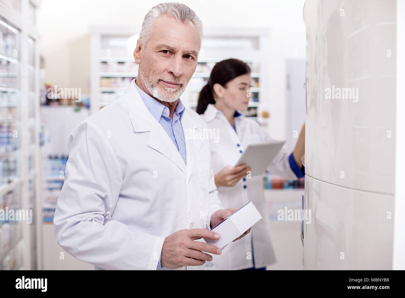 Experienced male pharmacist immersing in work Stock Photo - Alamy