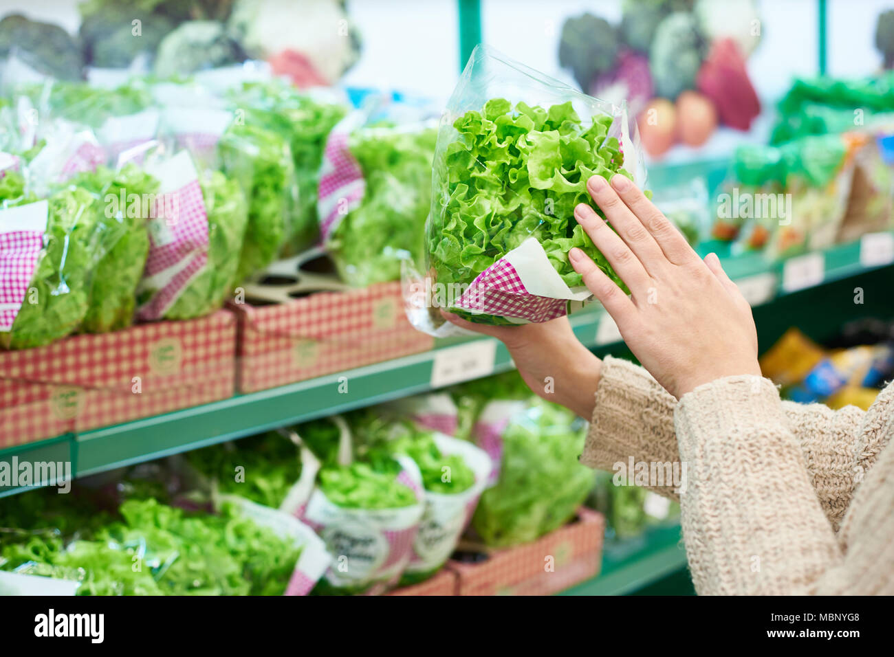 Woman chooses a green leaf salad in the grocery store Stock Photo - Alamy