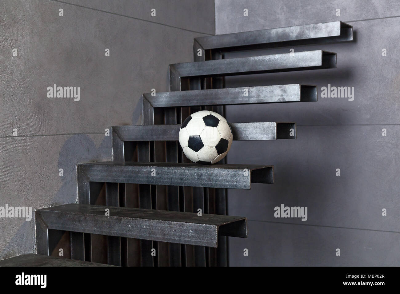 soccer ball lies on a metal staircase.soccer ball with metallic ...