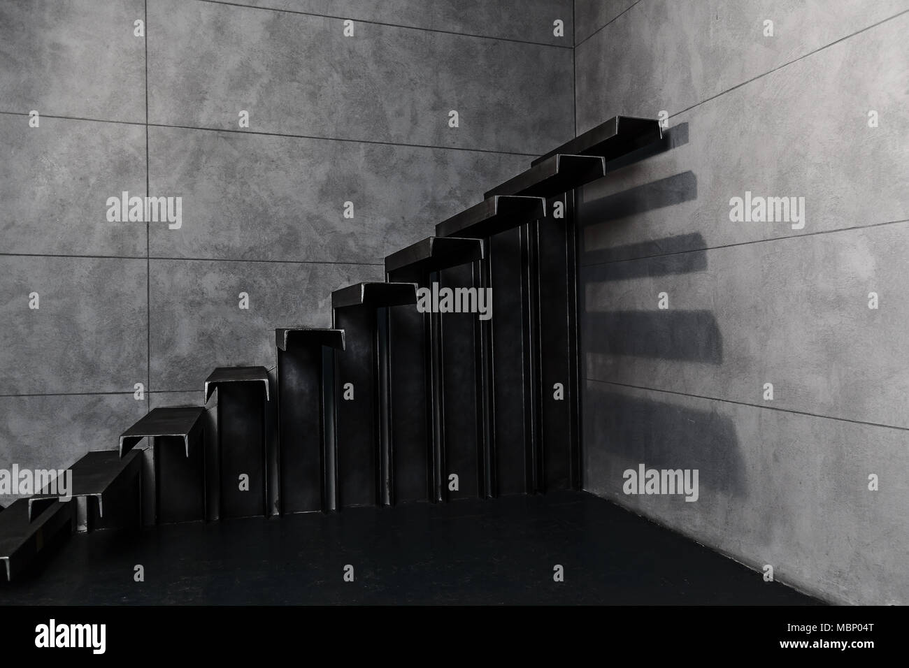 Vintage texture of a metal staircase without railings near the wall for ...