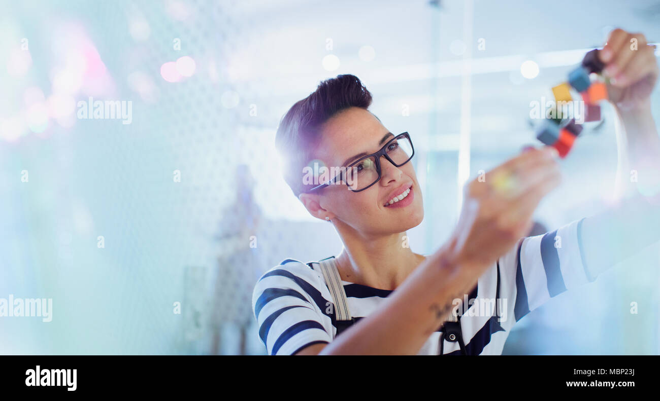 Curious, innovative female entrepreneur examining prototype Stock Photo ...