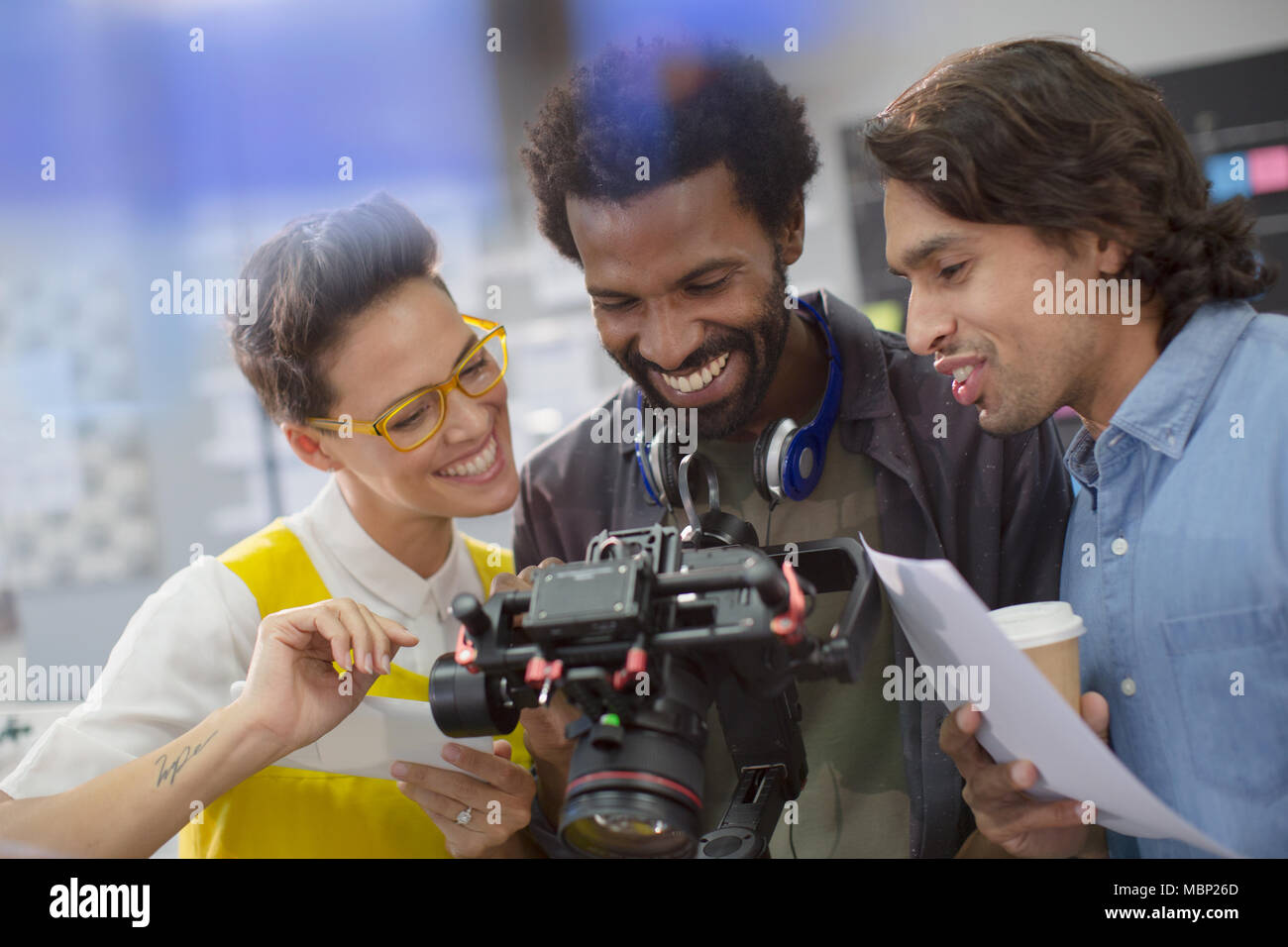 Smiling journalists and cameraman using digital camera Stock Photo - Alamy