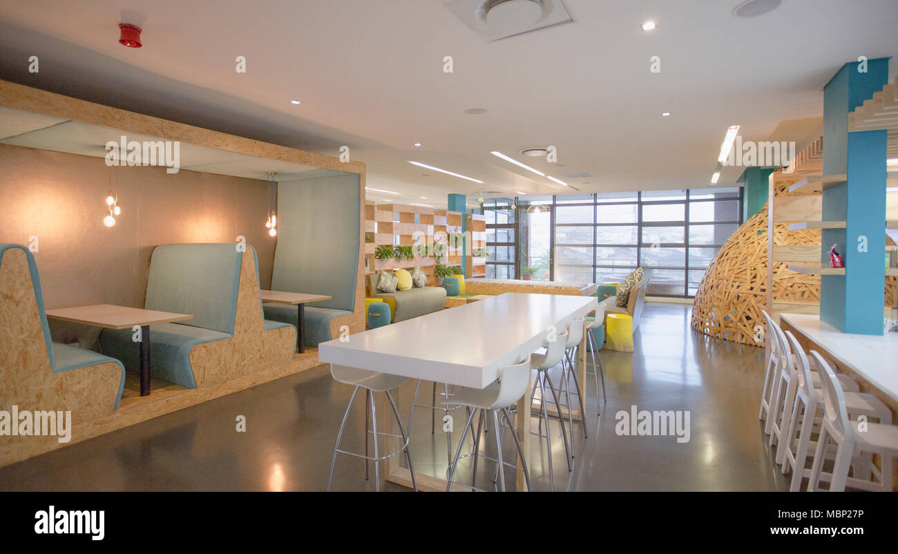 Modern, creative shared workspace with table and booths Stock Photo - Alamy