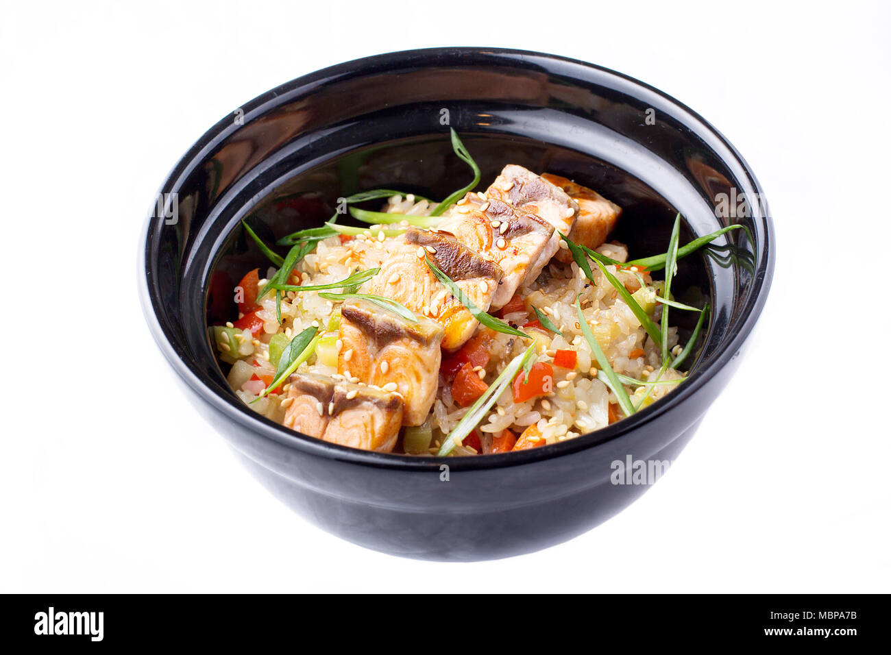 Japanese food. Rice with vegetables and fried salmon in a black bowl ...