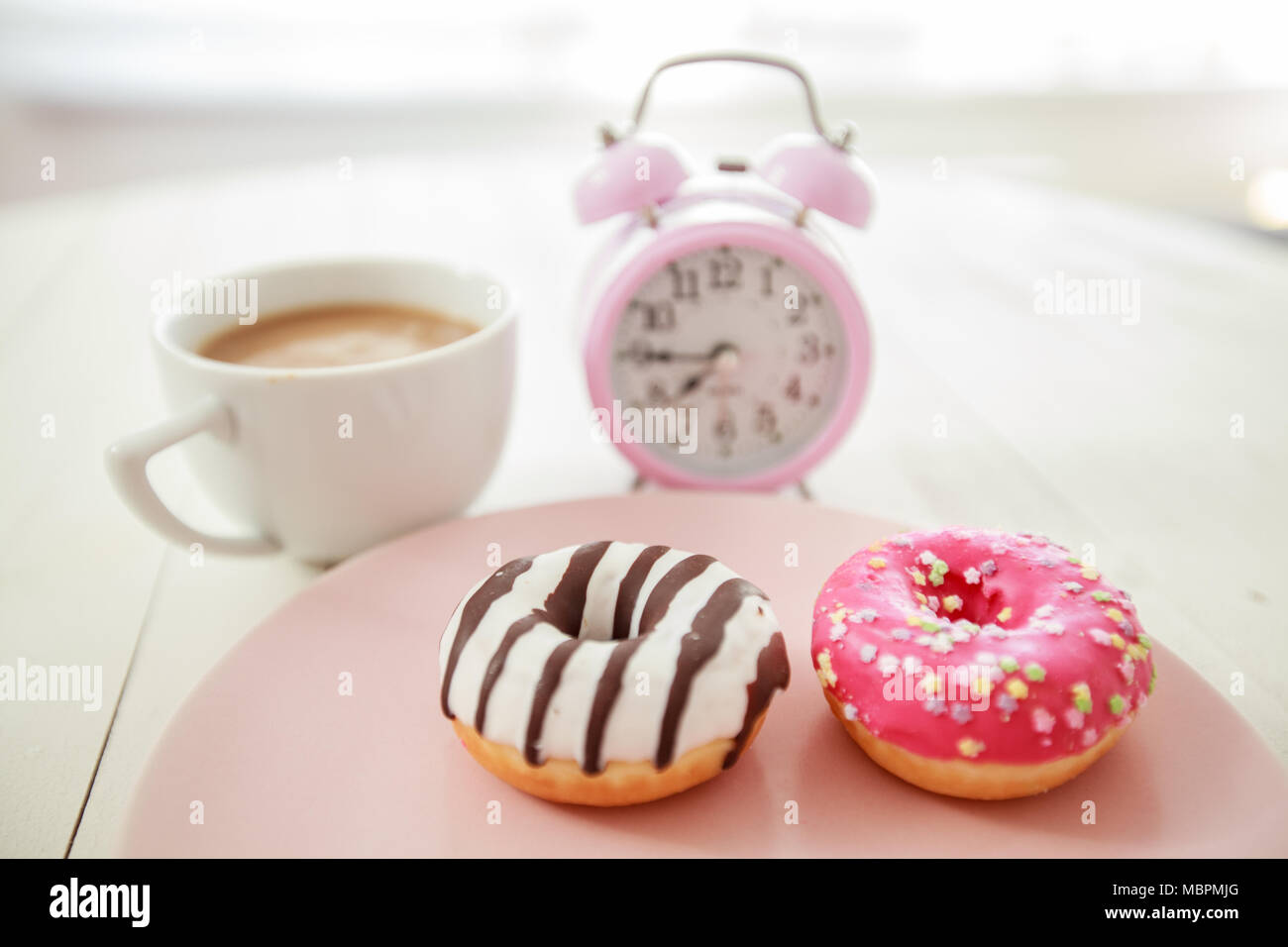 Delicious donuts and Cup of coffee ready for breakfast, retro alarm ...