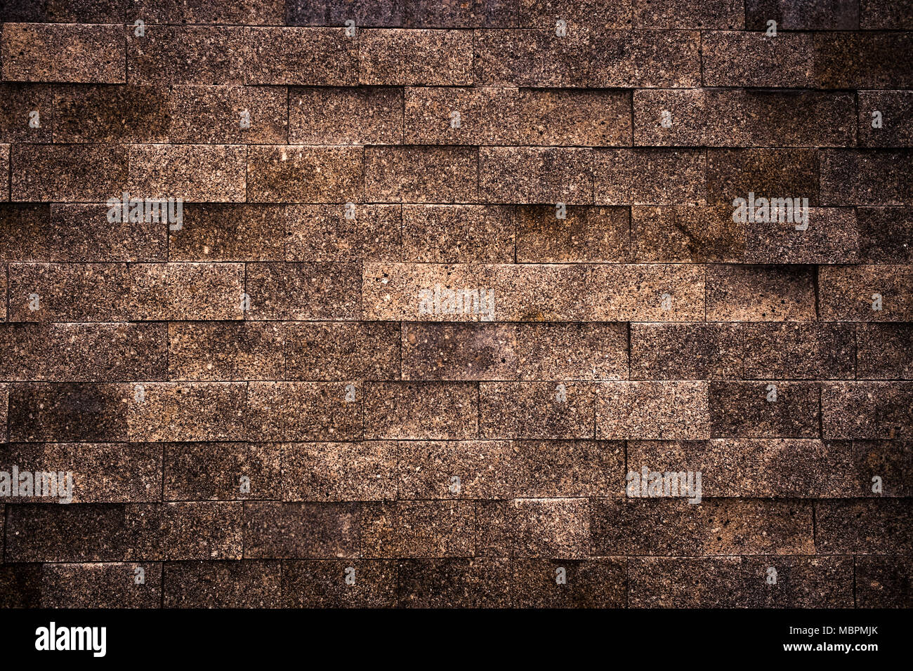 Stone wall of rectangular brown granite bricks as background Stock ...