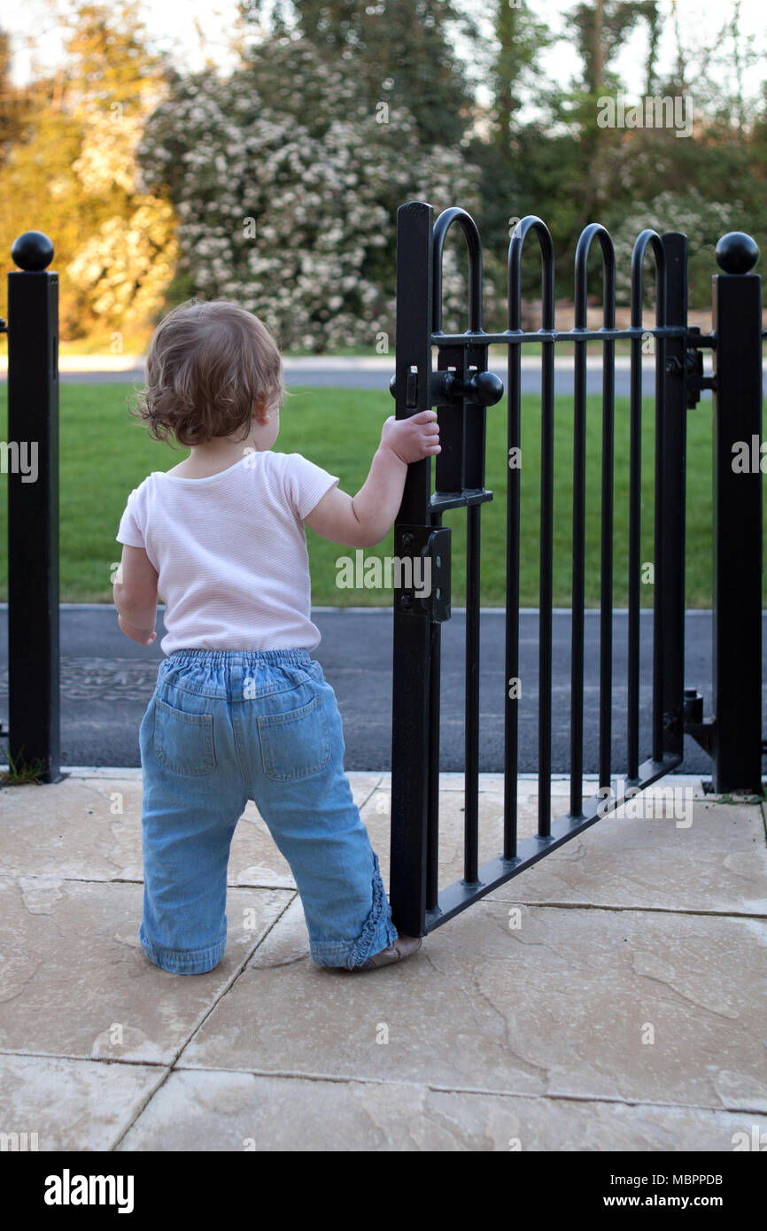 A young girl, aged one, opens the gate Stock Photo - Alamy