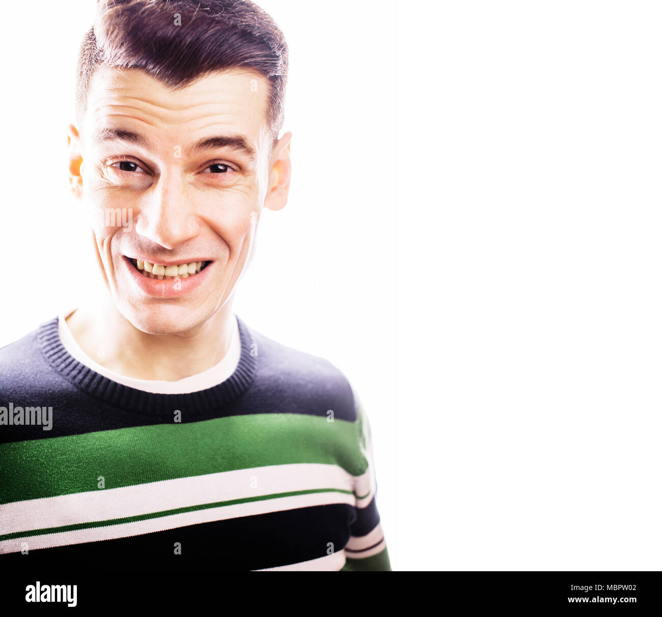 Portrait of a smart serious young man standing against white background ...