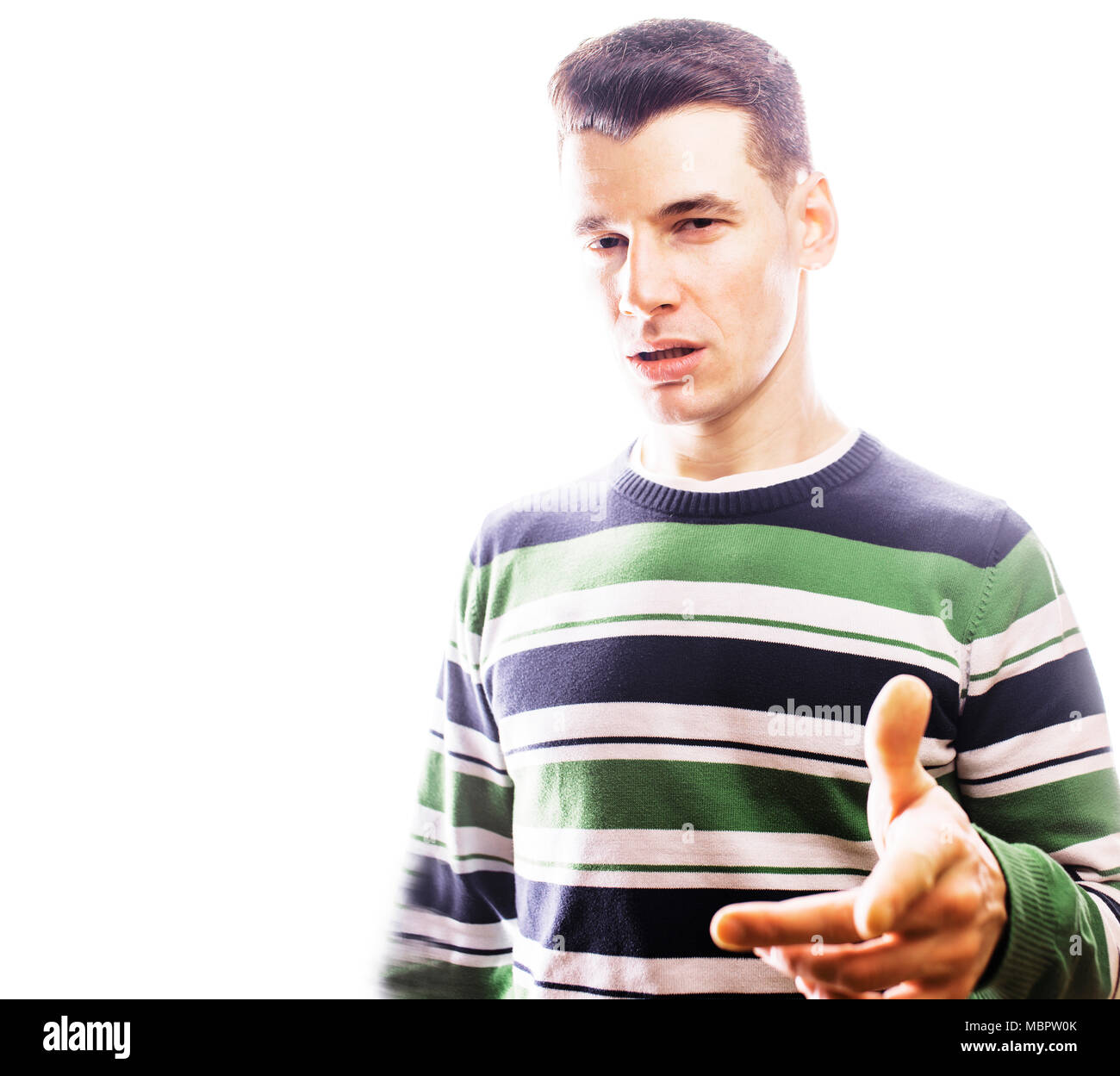 Portrait of a smart serious young man standing against white background ...