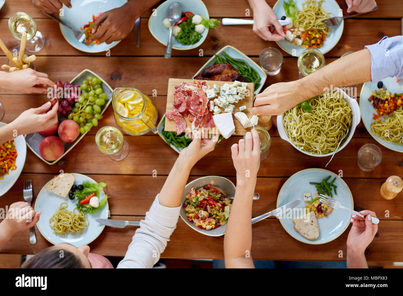 group of people eating at table with food Stock Photo - Alamy